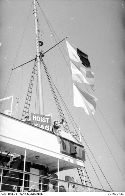 A hoist of signal flags on the yard arm of the Naval Examination ...