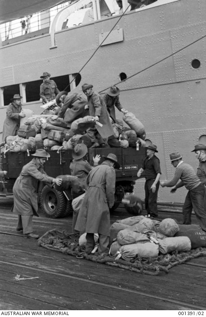 Troops offloading luggage and equipment from a truck into a sling for ...