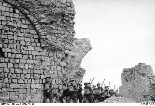 Members of the 2/1st Field Engineers marching through the ruins of a ...