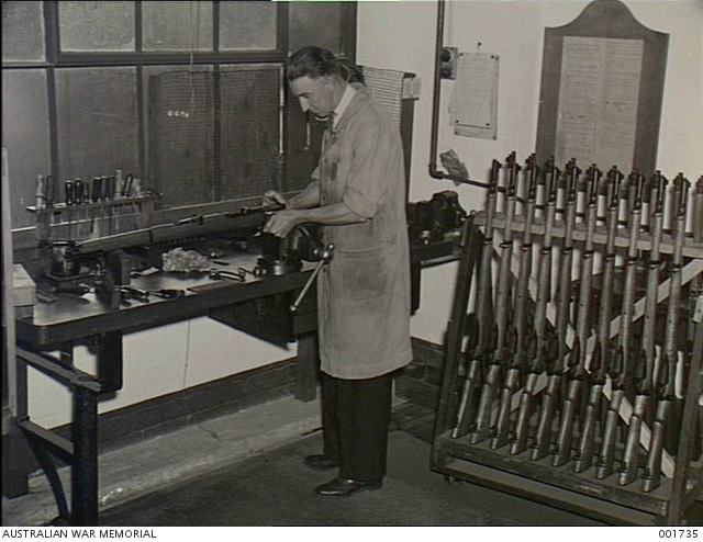A munitions employee at the Small Arms Factory, checking completed ...