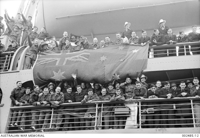 With a large Australian flag, soldiers of the 6th Division and a small ...