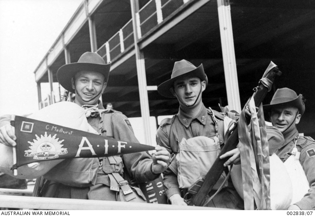 Three soldiers of the 6th Division pause at the top of the gangway ...