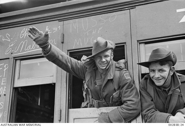 Two soldiers of the 6th Division look out from the carriage window of ...