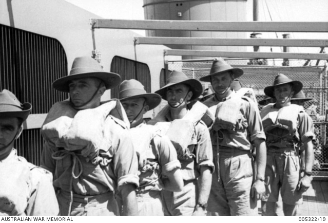 Troops wearing life jackets assembled on the deck of the troopship for ...
