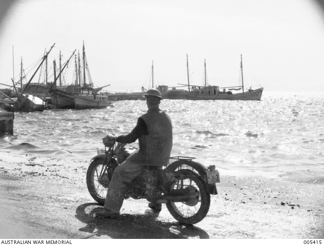 TOBRUK. A DESPATCH RIDER ON HIS MOTOR CYCLE LOOKING AT SMALL FISHING ...