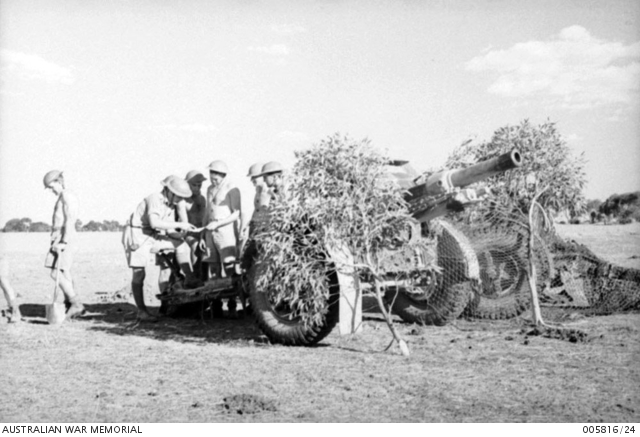 A field gun with its ammunition limber hastily camouflaged using the ...