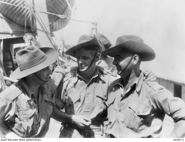 Three members of the 8th Division relax on the deck of the troop ...