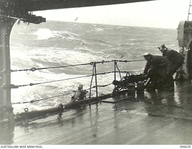 TWO CREWMEN OF HMAS PERTH SECURE EQUIPMENT ON DECK DURING HEAVY WEATHER ...