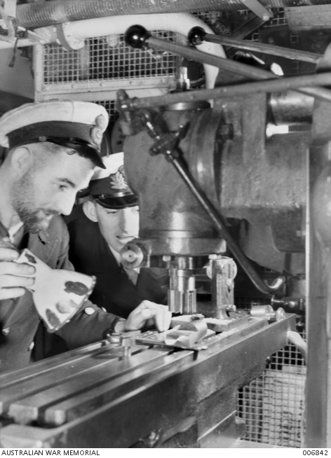 TWO CREW MEMBERS OPERATING MACHINERY ON BOARD HMAS PERTH. ON THE LEFT ...