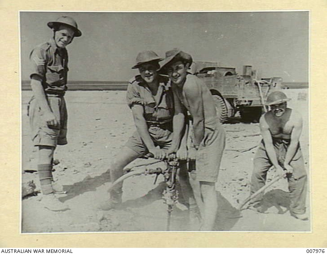 AN AUSTRALIAN SAPPER AND A ROYAL ENGINEER SHARING A PNEUMATIC DRILL ...