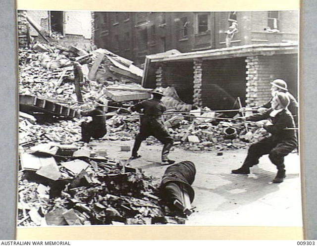 LONDON. A TUG OF WAR WITH A PIECE OF WRECKAGE WHEN CLEARING DEBRIS FROM ...