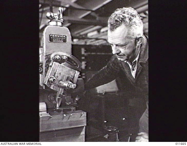 GENERAL MOTORS FACTORY. THE MACHINE TOOL THIS WORKER IS OPERATING HAS ...