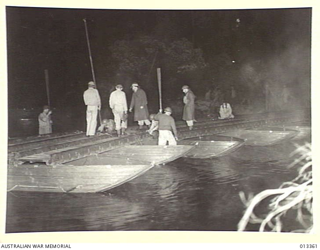 NIGHT MANOEUVRES. ARMY ENGINEERS CONTRUCTING A PONTOON BRIDGE DURING A ...