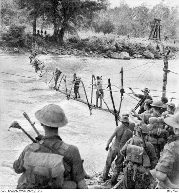 NEW GUINEA. ON ROAD TO BUNA AUSTRALIAN TROOPS CROSS A STREAM ON AN ...