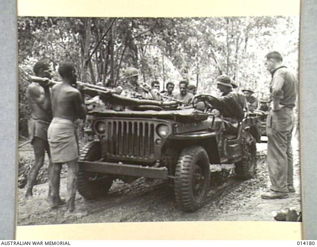 PAPUA. SANANANDA AREA. A WOUNDED AUSTRALIAN IS PLACED ON A JEEP BY ...