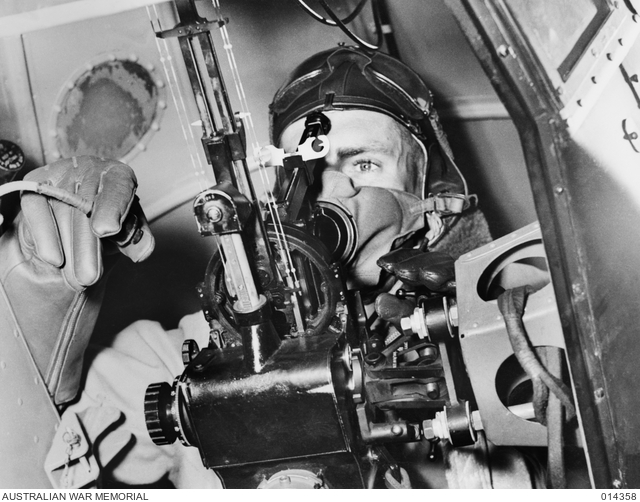 A photograph taken from the ground showing a trainee bomb aimer in his ...