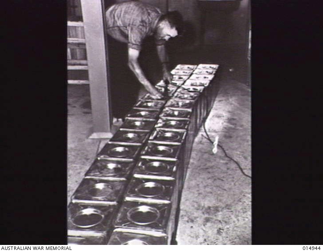 AUSTRALIA AT WAR. PICTURE SHOWS ROY TUCKER SOLDERING THE LIDS ON 21 ...