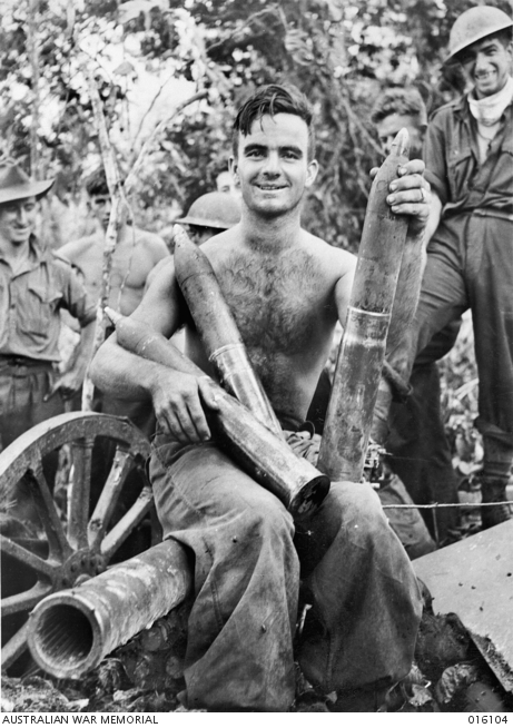 Troops stand around a Japanese 75mm field gun which was in a position ...