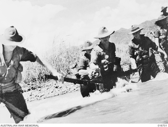 Finisterre Range, New Guinea. Troops cross a stream against a current ...