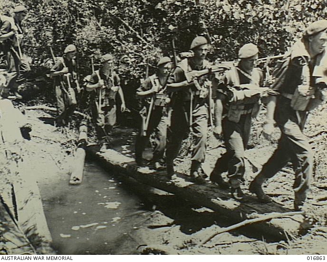 Dutch New Guinea. Soldiers crossing a jungle stream by a log over the ...
