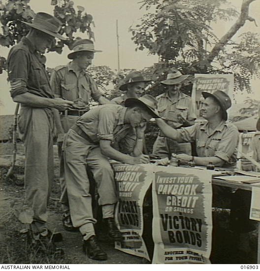 New Guinea. Troops fill in loan application forms. At the desk is Mr F ...