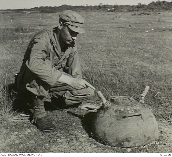 Gasmata, New Guinea. American reconnaissance patrol member points to a ...