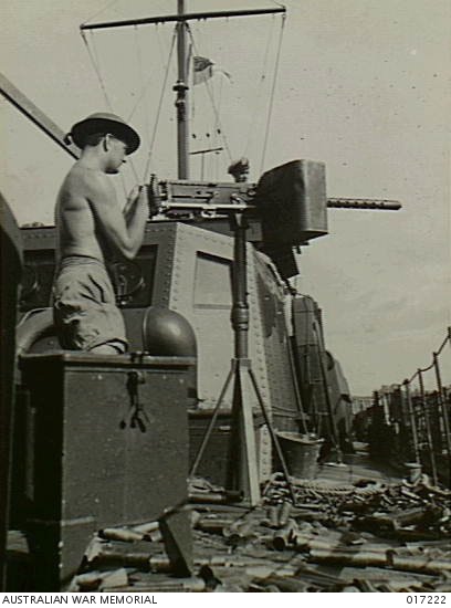 New Guinea. Litter of battle, spent shell cases, lies at the feet of ...