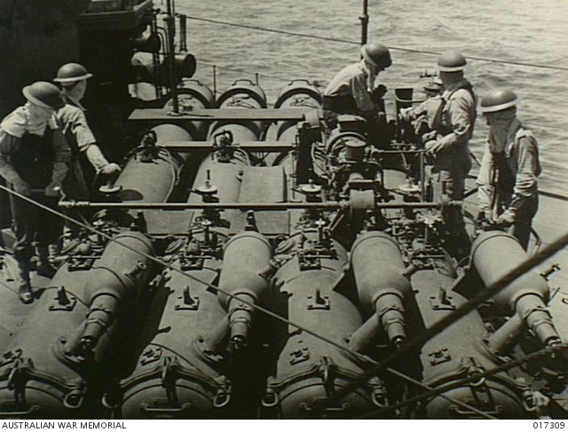 At Sea, New Guinea. Preparing torpedo tubes for action on board the ...