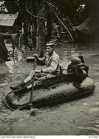 New Guinea. Corporal Bill Roberts of Kentucky is paddling his gear to ...