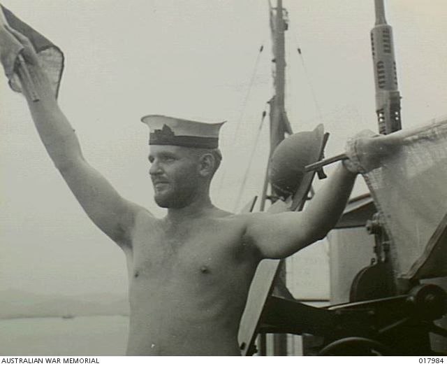Philippines. Signalman L. J. Searle of Bondi, NSW, flag signalling from ...