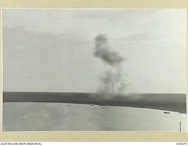 An actual bomb burst on Tobruk Harbour foreshore. | Australian War Memorial