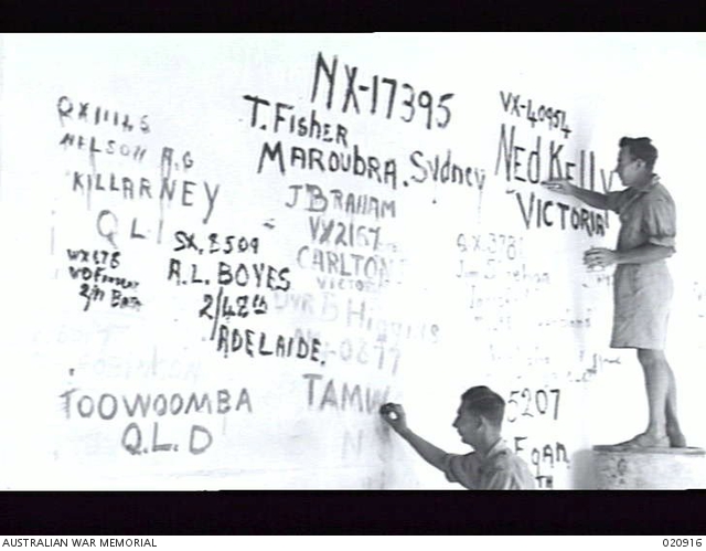 Australian soldiers writing their names on the wall of a building in ...