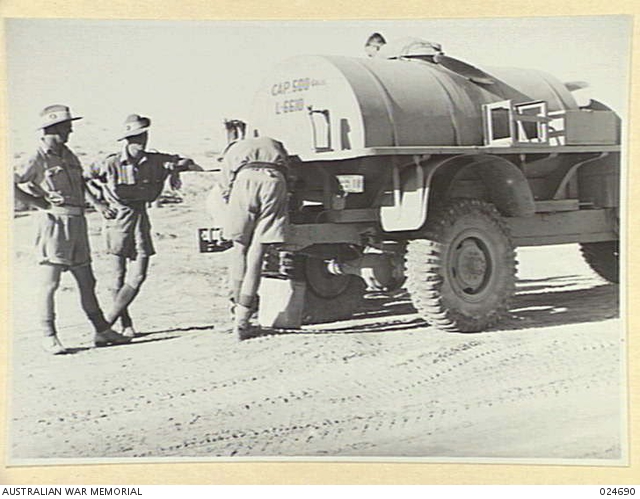 FILLING WATER TINS FROM A 500-GALLON WATER TANK AT REAR HEADQUARTERS ...