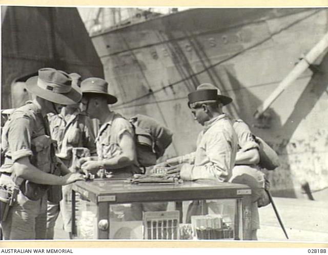 BOMBAY, INDIA. 1942-03-25. AN INDIAN VENDOR ON THE WHARF DOES A BRISK ...