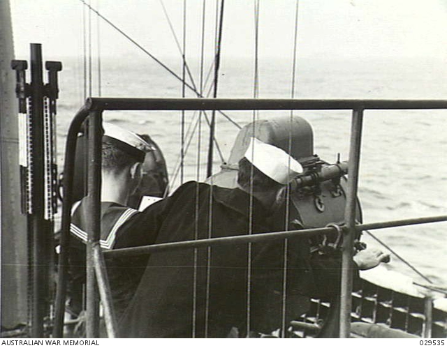 HMAS AUSTRALIA, AT SEA. 1943-02. AN AMERICAN NAVAL LIAISON SIGNALMAN ...