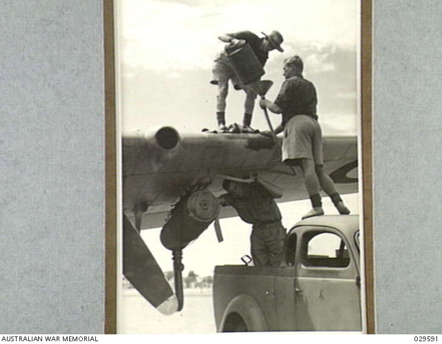 COROWA, NSW. 1943-03. FILLING THE CONTAINERS ON A BEAUFORT BOMBER OF ...