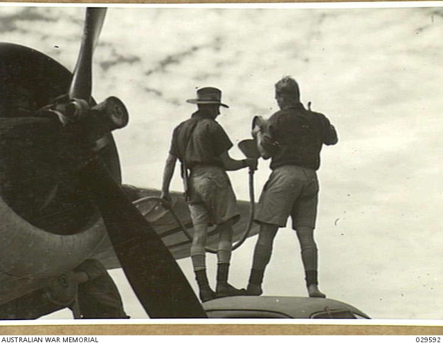 COROWA, NSW. 1943-03. FILLING THE CONTAINERS ON A BEAUFORT BOMBER OF ...