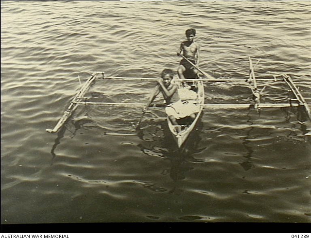 Biak Island, Dutch New Guinea. c. 1943. Two native boys paddling an ...