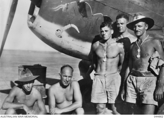 76 SQUADRON GROUND PERSONNEL IN FRONT OF A P.40 WITH NOSE ART. LEFT TO ...