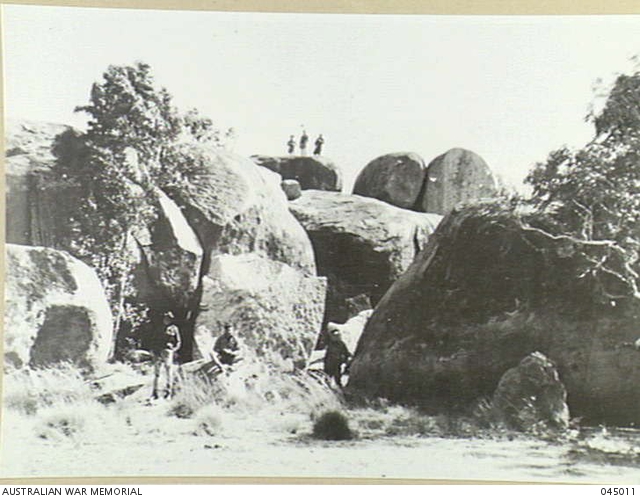 NT. 1941. ROCK FORMATION KNOWN AS DEVILS MARBLES. THE MEN CLIMBING ...