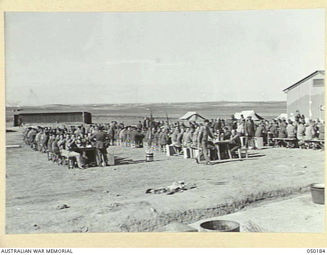 JULIS, PALESTINE. 1942-12-25. MEN SITTING DOWN TO CHRISTMAS DINNER ...