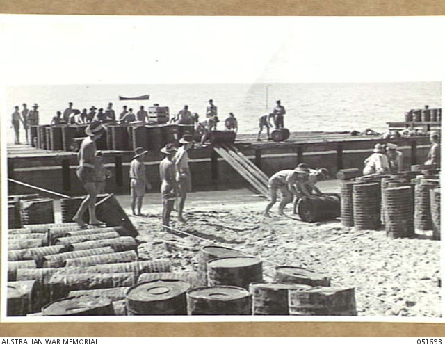 POTSHOT, WA. 1943-04-28. UNLOADNG DRUMS OF BITUMEN FROM BARGES, FOR USE ...
