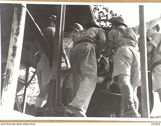 DARWIN, NT. 1943-06-23. RAMMING SHELL INTO POSITION IN NO. 2 GUN AT THE ...