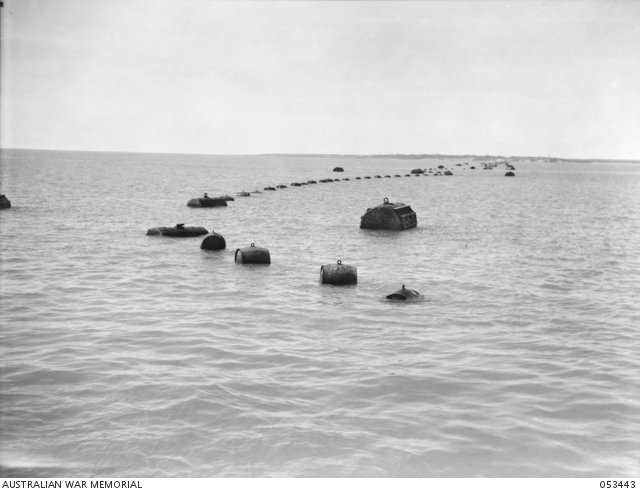 DARWIN, NT. 1943-07-06. BOOM GATES OPEN TO ALLOW THE PASSAGE OF A SHIP ...