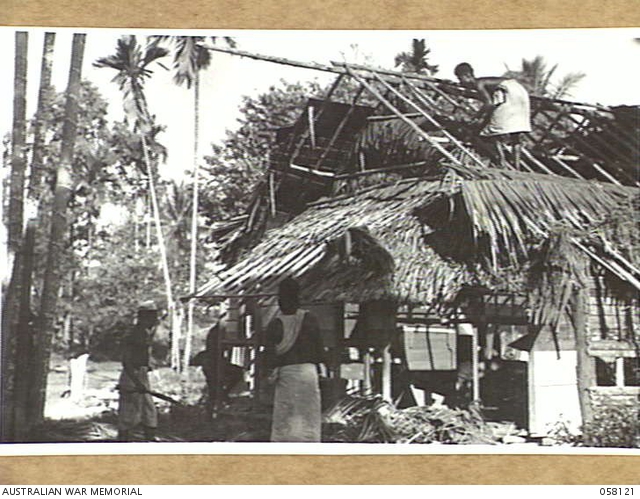 SALAMAUA, NEW GUINEA, 1943-09-26. NATIVES THATCHING THE BOMB DAMAGED ...