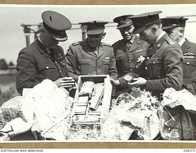 LANGWARRIN, VIC, 1943-10-26. AIR FORCE AND ARMY OFFICERS EXAMINING TINS ...