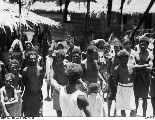HOPOI, NEW GUINEA, 1943-10-20. A NATIVE INTERPRETER TRANSLATING THE ...