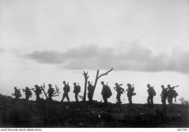 WAREO, NEW GUINEA. 1943-12-09. SILHOUETTED AGAINST THE EVENING SKY, MEN ...