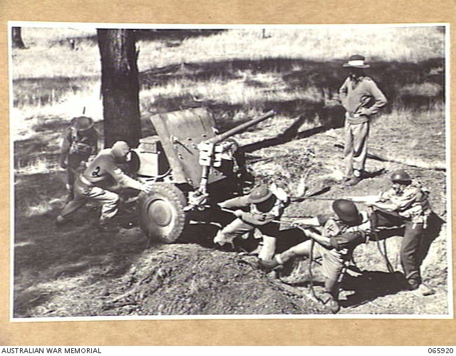 BATHURST, NSW. 1944-04-18. TROOPS LOWERING A 2-POUNDER TANK ATTACK GUN ...