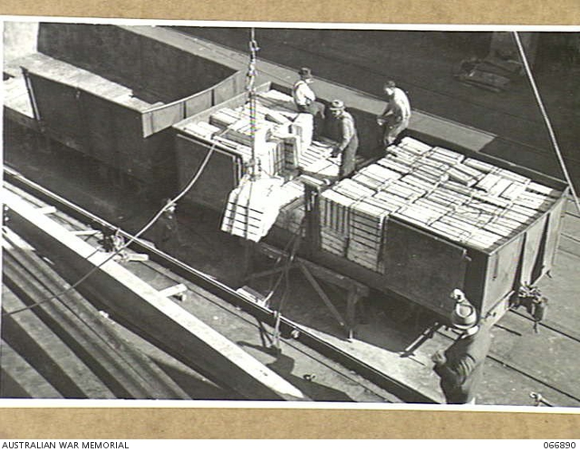 SYDNEY, NSW. 1944-06-10. 75MM SHELLS BEING LIFTED FROM A RAILWAY TRUCK ...